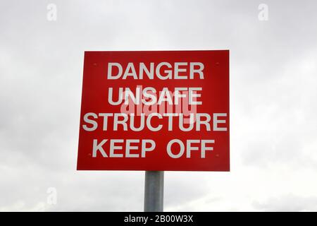 Danger unsafe structure warning sign attached to red brick wall Stock ...