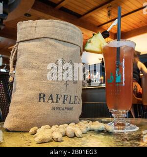 Inside the famous Raffles Long Bar, Singapore showing a traditional bag ...