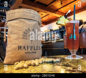 Inside the famous Raffles Long Bar, Singapore showing a traditional bag ...