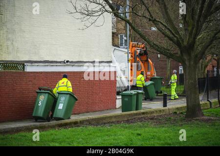 Rubbish collection, bin men working at the back of a lorry, London ...