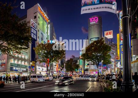 Evening view of a city street with a prominent tower in the background ...