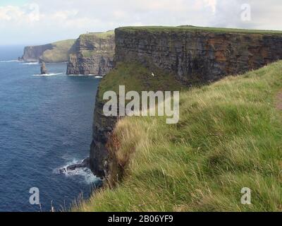colorful ocean views, green grassy rocks, rocks and blue water. The ...