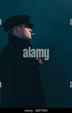 Retro mobster with cigarette holds gun. Side view Stock Photo - Alamy