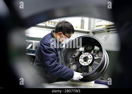 Chinese workers manufacture aluminium-alloy car rims at the plant of ...
