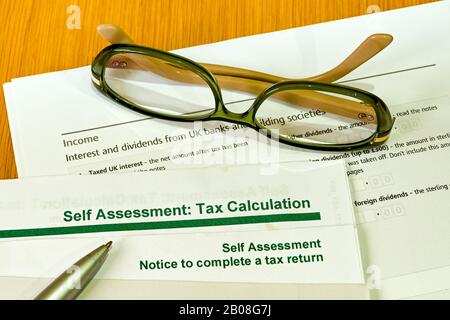 HMRC self assessment tax forms with pen and calculator Stock Photo ...