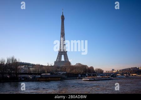 A tourist boat passes by the Eiffel Tower during a sunny day in Paris ...