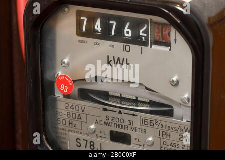 An old style mechanical electricity meter alongside a row of plug in ...