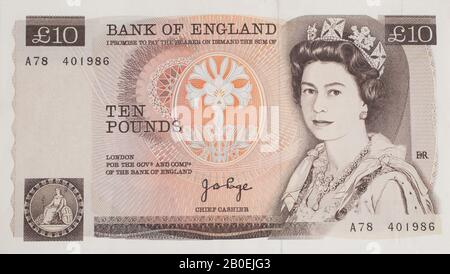 Old British one pound note with pre-decimal imperial coins in close ...