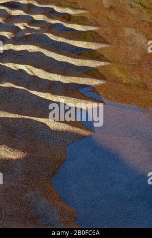 Abstract detailed tidal patterns in the sand at low tide on Penbryn ...
