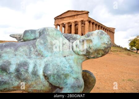 Statue of fallen Icarus in bronze in front of the 2,400 year old Temple ...