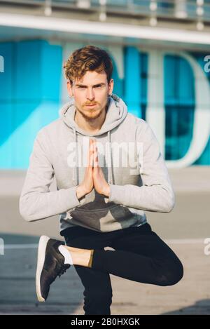 Young redhead man training yoga at sport center Stock Photo - Alamy