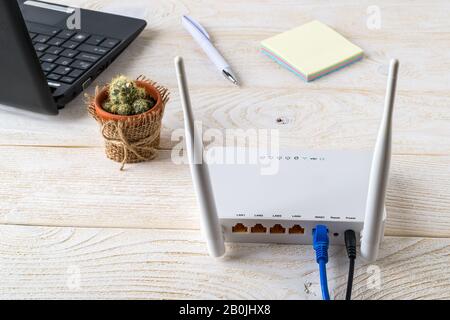 home wireless router with ethernet cables plugged in on blue background ...