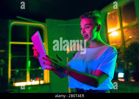 Astonished. Cinematic portrait of stylish woman in neon lighted ...