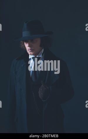 Mysterious victorian man in black coat and hat Stock Photo - Alamy