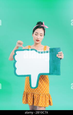 Young woman holding a dislike icon over color background Stock Photo ...