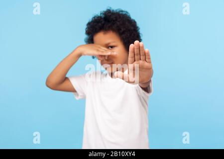Disgusted little boy showing STOP gesture and frowning face, feeling ...