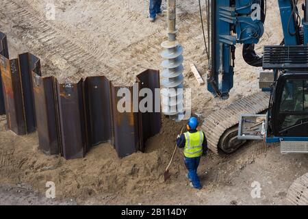 Excavator at earthworks on construction site. Backhoe loader digs a pit ...