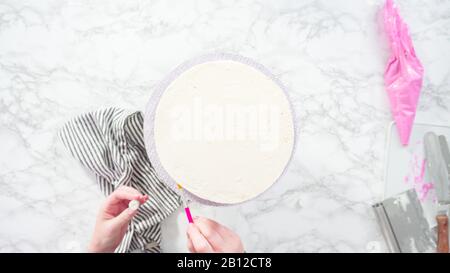 Flat lay. Step by step. Decorating round funfetti cake with pink and ...