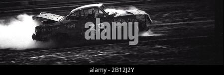 1970s, historical, a banger racing car with smoke pouring out from a ...