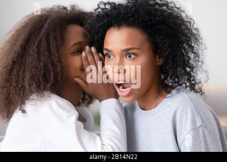 Amazed african american child in red dress holding cellphone with blank ...