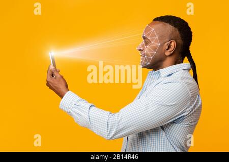 Mature african man scanning his face with mobile app Stock Photo - Alamy