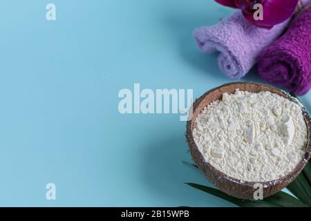 Collagen powder in half coconut with a spoon for measuring quantity ...