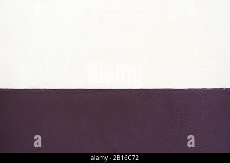 A beige wall is half painted with white paint. Abstract design ...