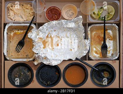 empty dirty plates and fast food cartons from an indian home takeaway ...