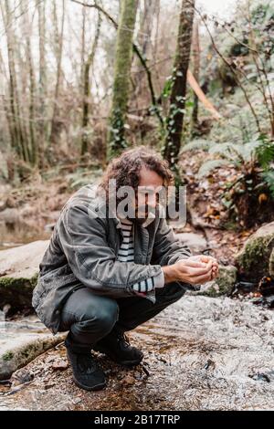 Man drinking water from a stream Stock Photo - Alamy