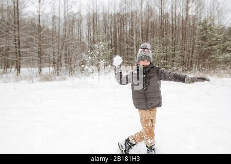 Children throwing snowballs in snowy winter park Stock Photo - Alamy