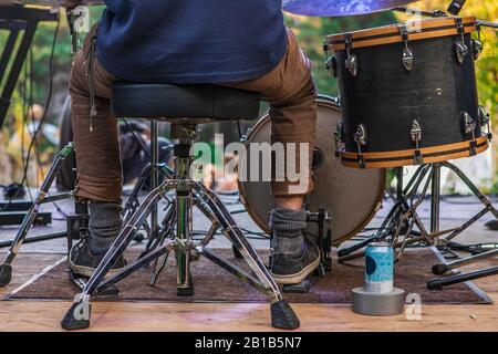 Drummer sitting at a drum set on stage at Sunday morning fish market ...