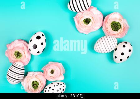 Easter eggs and ranunculus flowers frame on white background. Flat lay ...