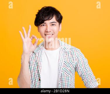 Satisfied handsome man showing a-ok signs and looking pleased ...