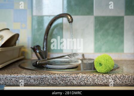 Green plastic mesh scourer, used to clean dishes, plates, pan and pots ...