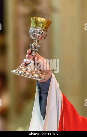 Minister showing the holy goblet during the rite of the Holy Communion ...