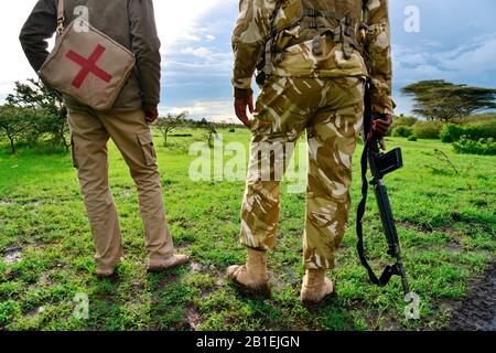 Armed rangers walking in a conservancy near the park, Masai Mara ...