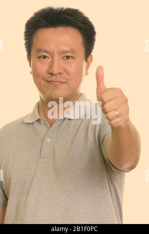 Studio shot of Japanese man giving ok sign Stock Photo - Alamy