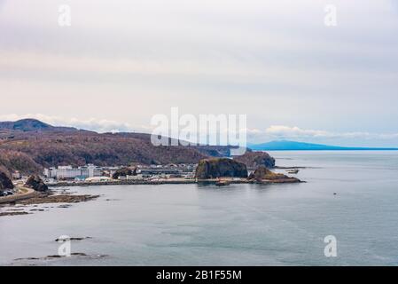 View of Utoro fishing port in springtime with Shiretoko mountain range ...