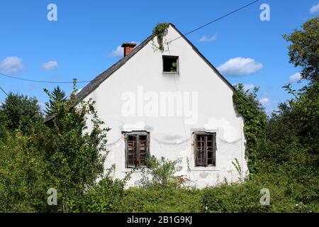 Abandoned small suburban family house ruins with large hole in middle ...