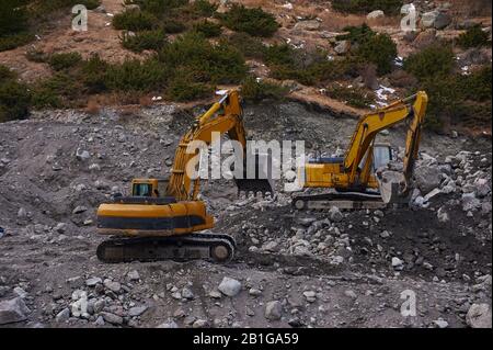Two excavators digging ground together Stock Photo - Alamy