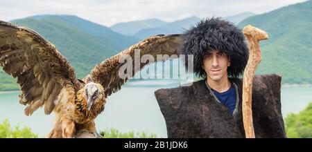 Georgian man in a beech costume on a background of mountains. Selective ...