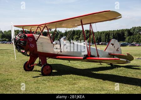 red biplane airplane on meadow Stock Photo - Alamy