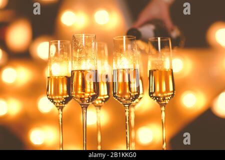 Transparent wineglasses with champagne placed on blurred background of ...