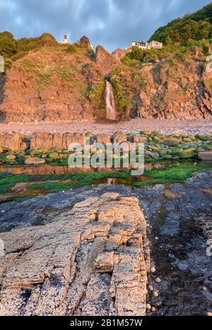 Coastal waterfall on the beach at Bucks Mills at the bottom of the ...