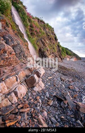 Coastal waterfall on the beach at Bucks Mills at the bottom of the ...