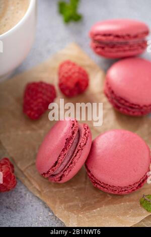 Colorful sweet macarons or macaroons, cherry flavored cookies on pink ...