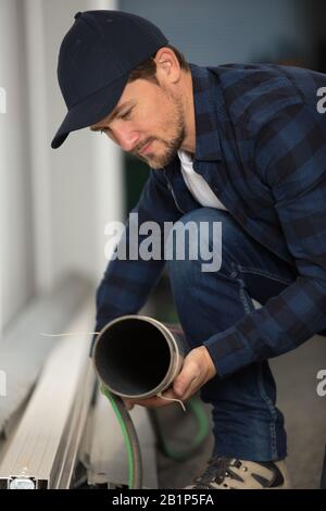 man working with ventilation pipes indoors Stock Photo - Alamy