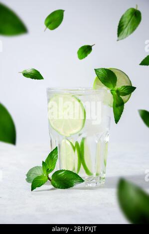Summer refreshing drink. Levitation of lemon slices with a straw on ...