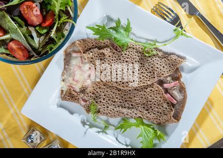 a Breton crepe with cheese and bacon in white plate Stock Photo - Alamy