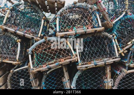 Close up of lobster pots made with blue and orange rope and white ...